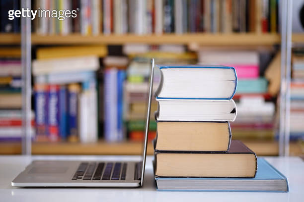 Stack of books and computer at the library 이미지 (1305103115) - 게티이미지뱅크