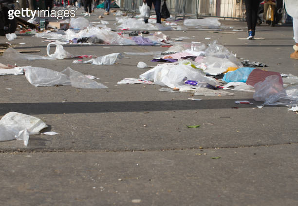 anonymous pedestrians walking through plastics and garbage polluted ...