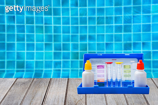 Water testing test kit on old wooden floor over Crystal clear swimming ...