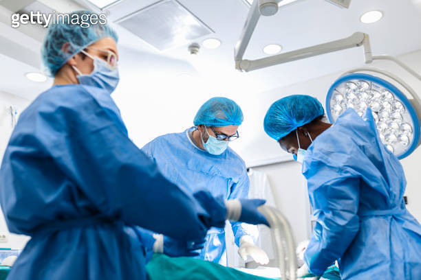 Group of medical team urgently doing surgical operation and helping ...