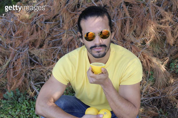 Man in yellow holding lemons 이미지 (1311123979) - 게티이미지뱅크