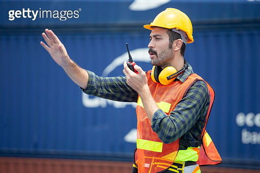 latin Foreman talking on the walkie-talkie control loading Containers ...