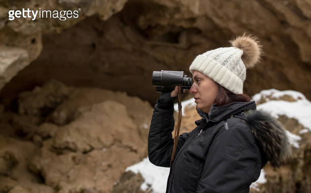 One woman, lady explorer and biologist standing in nature by waterfall ...