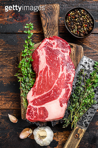 Raw Black Angus prime beef chuck roll steak on a cutting board with ...