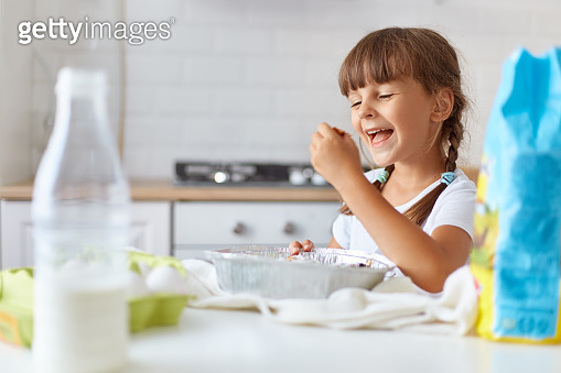 Portrait of cute girl taking baking, having happy facial expression ...