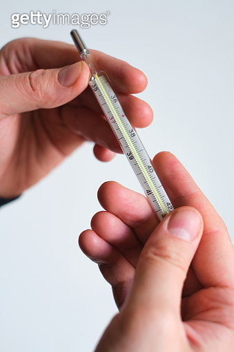 Medical thermometer close-up in the hands of a man. Traditional ...
