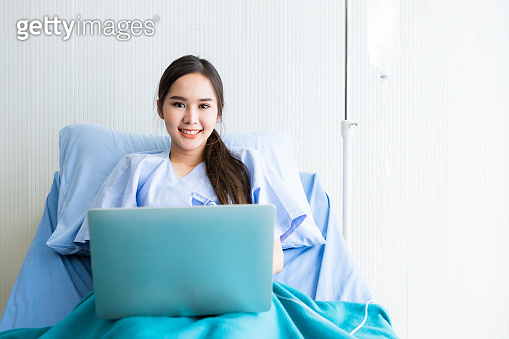 Asian young female patient smiley face working with laptop computer on ...