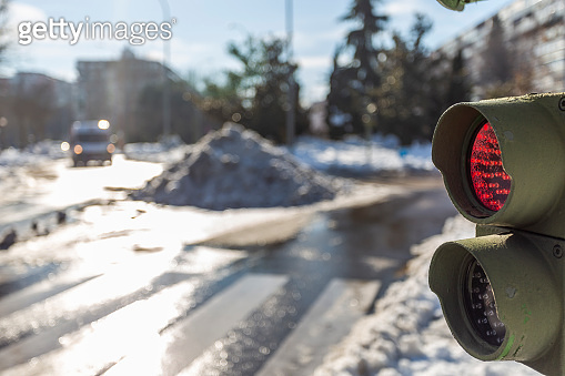 close-up shot of the red light of an avenue traffic light after a heavy ...