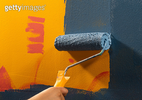 Wet blue paint on a wall, with a hand, holding a paint roller 이미지 ...