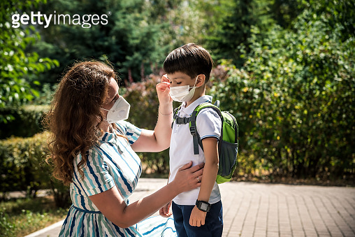 Family with kids in face mask going to school or kindergarten. Mother ...