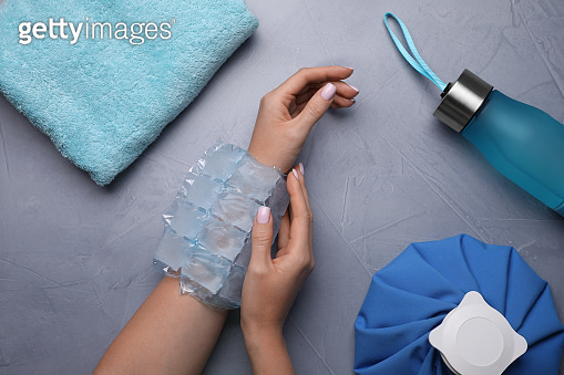 Woman with ice pack at grey table, top view. Heat stroke treatment 이미지 ...