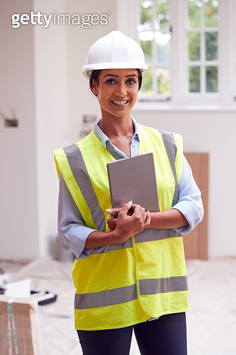 Portrait Of Female Building Surveyor Wearing Hard Hat With Digital ...