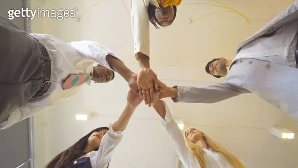 Group of multi ethnic successful business people stacking hands ...