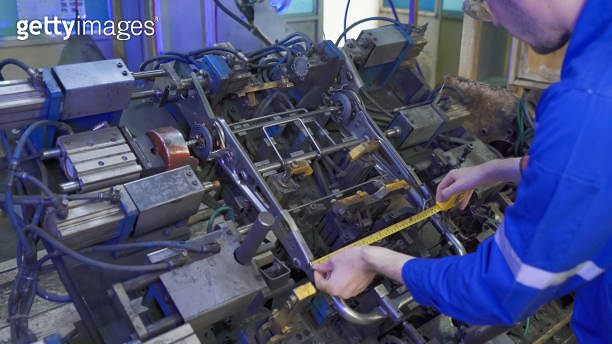 Industrial worker on quality control using steel measuring tape measure ...