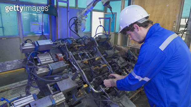 Industrial worker on quality control using steel measuring tape measure ...