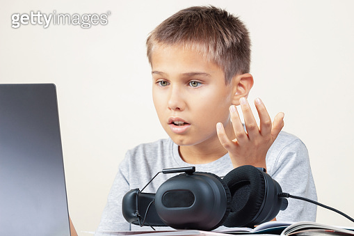 Shocked annoyed upset child with laptop computer and headphones sitting ...