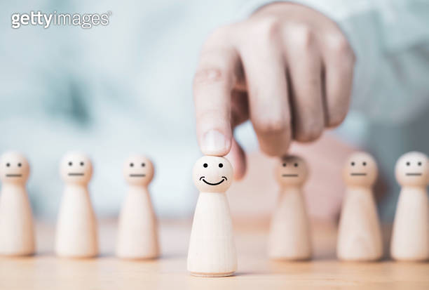 Businessman pointing and pushing wooden model in front of others model ...