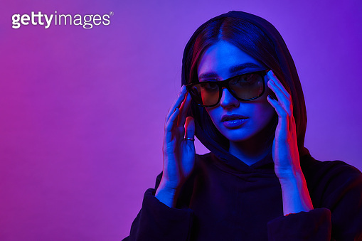 Girl posing in a studio in a trendy neon light. Woman in sunglasses and ...