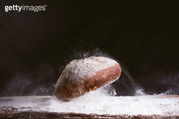 spectacular image of fresh and rustic golden bread falling on wood ...