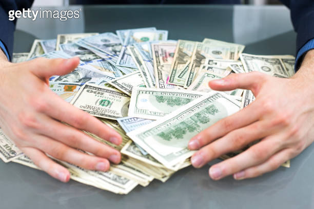 Business man is raking in a pile of money on the table 이미지 (1312694269 ...