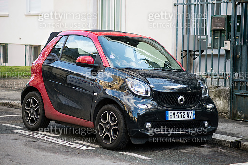 Front view of black and red smart microcar parked in the street 이미지 ...