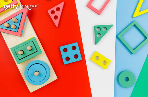 Multicolored wooden blocks on red blue background. Trendy puzzle toys ...