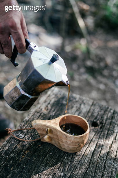 Making coffee in a stainless steel mocha kettle on a campfire. Moka pot ...