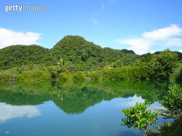 Lush forests reflected in the clear waters of Airai State, Palau. 이미지 ...