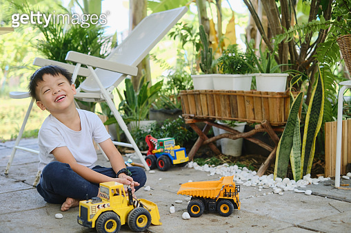 Cute Asian young kindergarten boy playing with pebbles and toy ...
