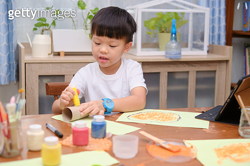 Cute little kindergarten boy enjoy using glue doing arts at home, Fun ...