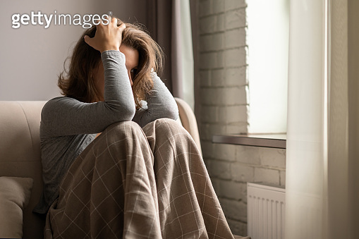Sad scared woman in panic attack grabbing her head by hand. Lonely girl ...