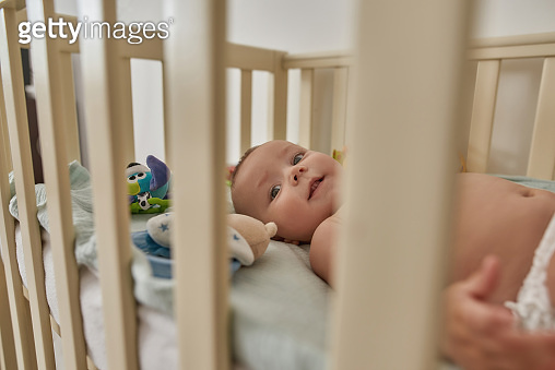 Cheerful baby looking at camera through crib bars 이미지 (1343863267) - 게티 ...