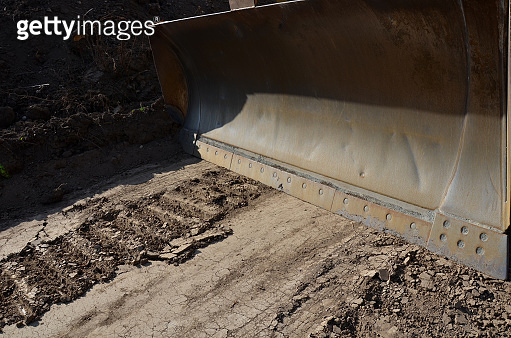 grader, bulldozer flats the road surface. tears unevenness with a large ...
