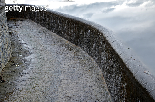 bridge over safety spillway of the dam. stone bridge with natural ...
