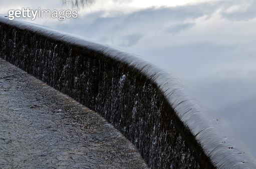 bridge over safety spillway of the dam. stone bridge with natural ...