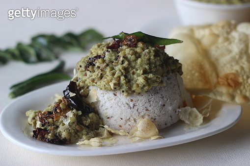 Steamed rice cake served with green gram curry and papad. A favorite ...