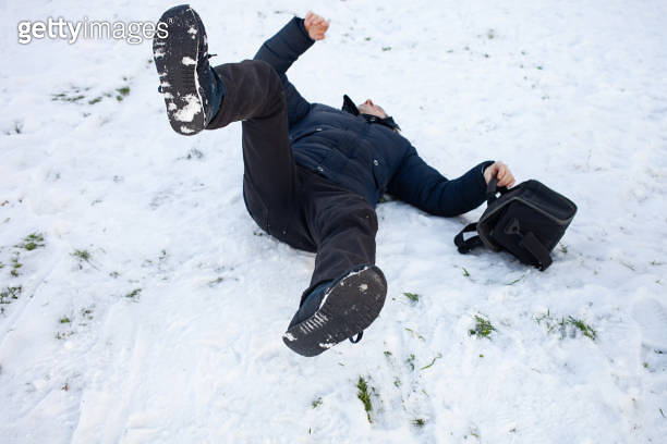 A man falls in the snow. The man slipped and was injured. Falling on ...