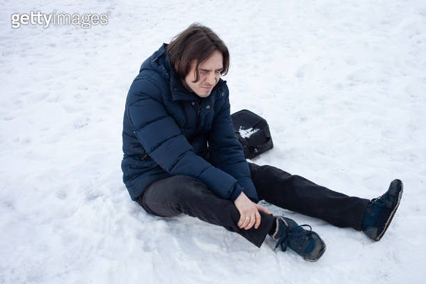 A man falls in the snow. The man slipped and was injured. Falling on ...