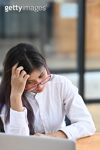 Bored businesswoman sitting at office desk in front of laptop computer ...