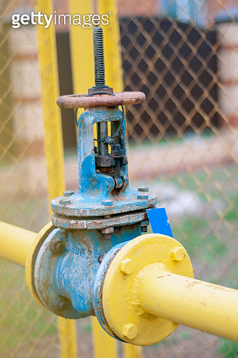 Natural gas gate valve, painted blue with yellow pipes attached, close ...