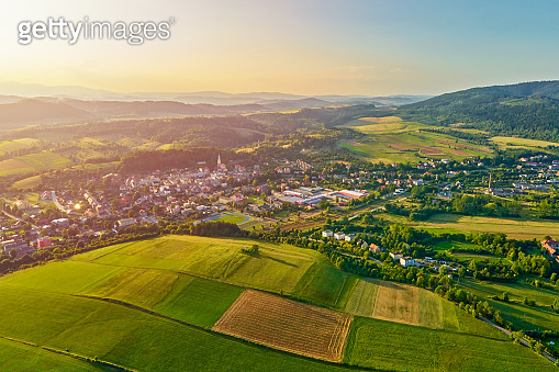 Village near mountain and agricultural fields at sunset. Nature ...