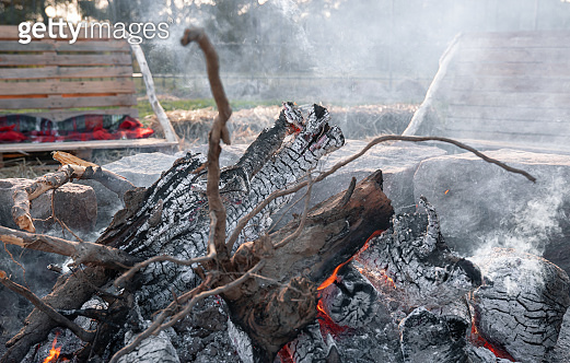 Close-up of large logs of a tree in a dying fire. (1350690661) - 게티이미지뱅크