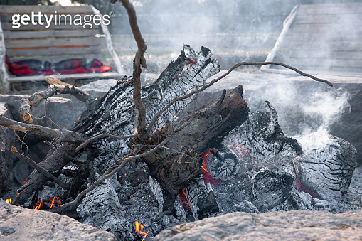 Close-up of large logs of a tree in a dying fire. (1350690649) - 게티이미지뱅크