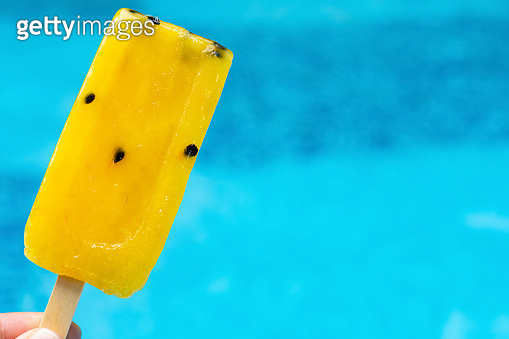 a passion fruit popsicle in front of a swimming pool (1329355819) - 게티이미지뱅크