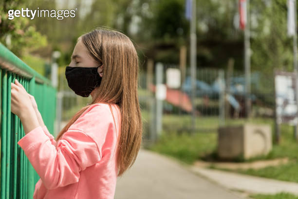 Girl with Protective Mask Trying to Open with Hands the Closed Fence of ...