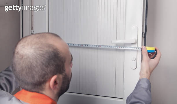 Caucasian man measuring door in room. 이미지 (1299224349) - 게티이미지뱅크