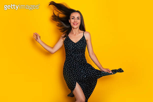 Excited happy cute modern woman in a summer dress is dancing and having ...