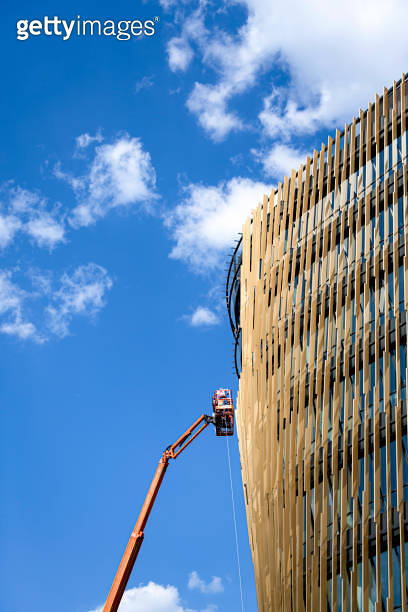 Window washer at work while washing windows on an office building stock ...