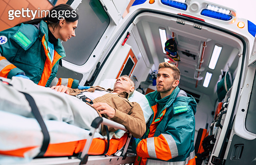 Serious and professional team of doctors in the ambulance moving on a ...