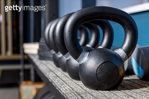 a row of large black weights on a shelf. sports equipment for training ...